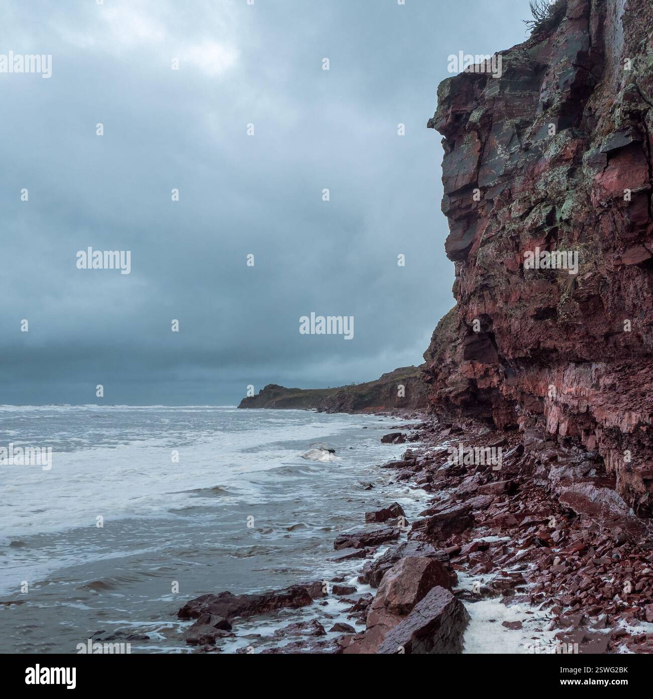 A rock cliff above the water with a tidal shoreline. White sea Stock ...