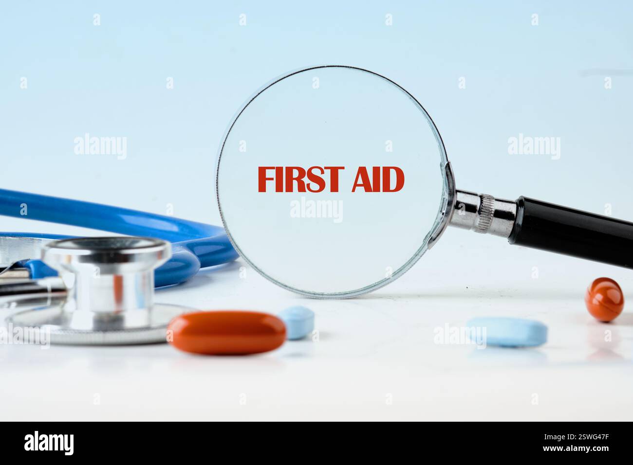 Magnifying glass focuses on the term first aid surrounded by medical ...