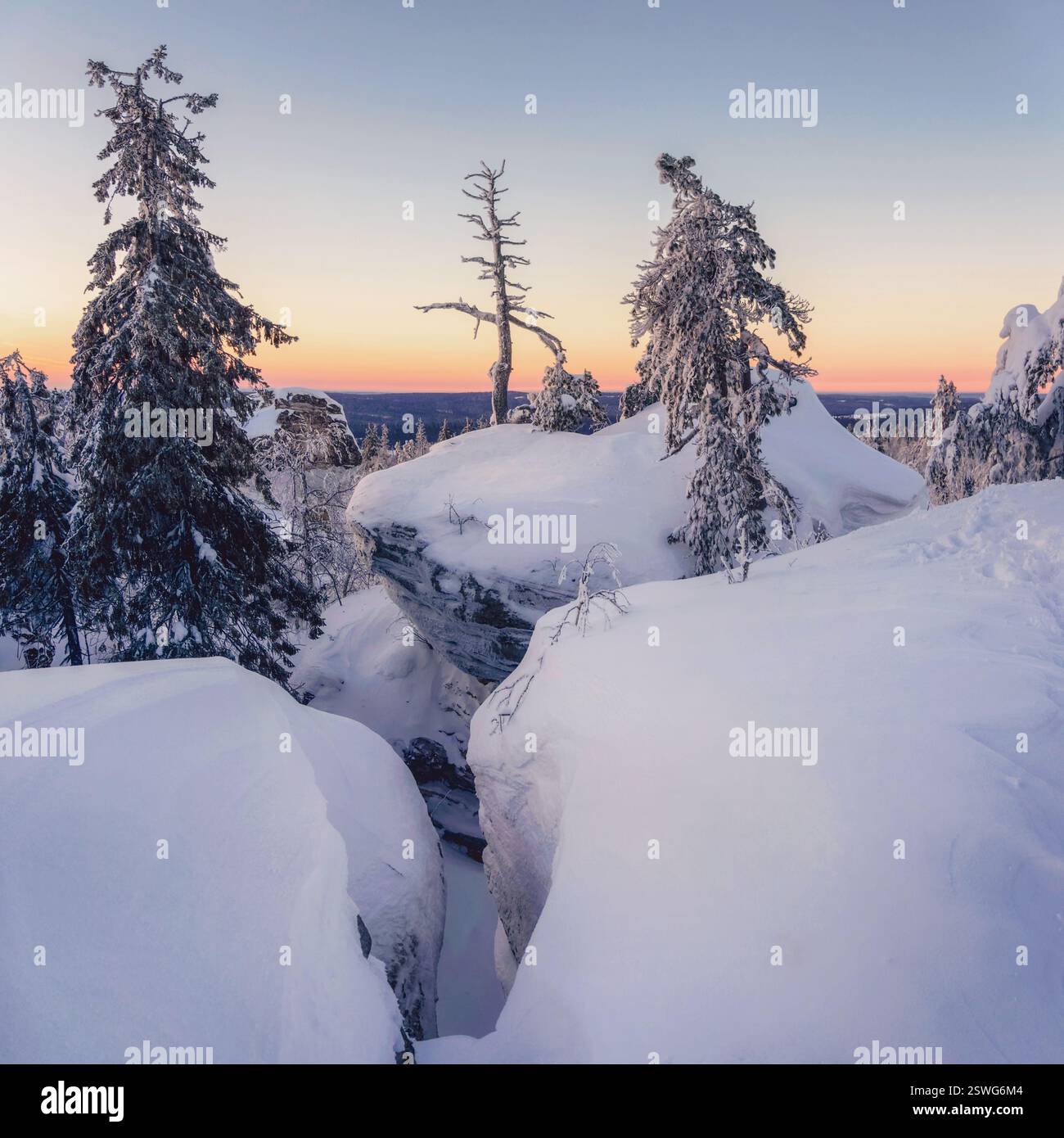Big granite rock is frozen and covered with snow. Nature landscape ...