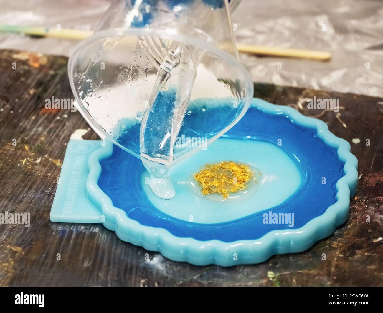 The art process of pouring epoxy resin into a golden toy. Technology ...