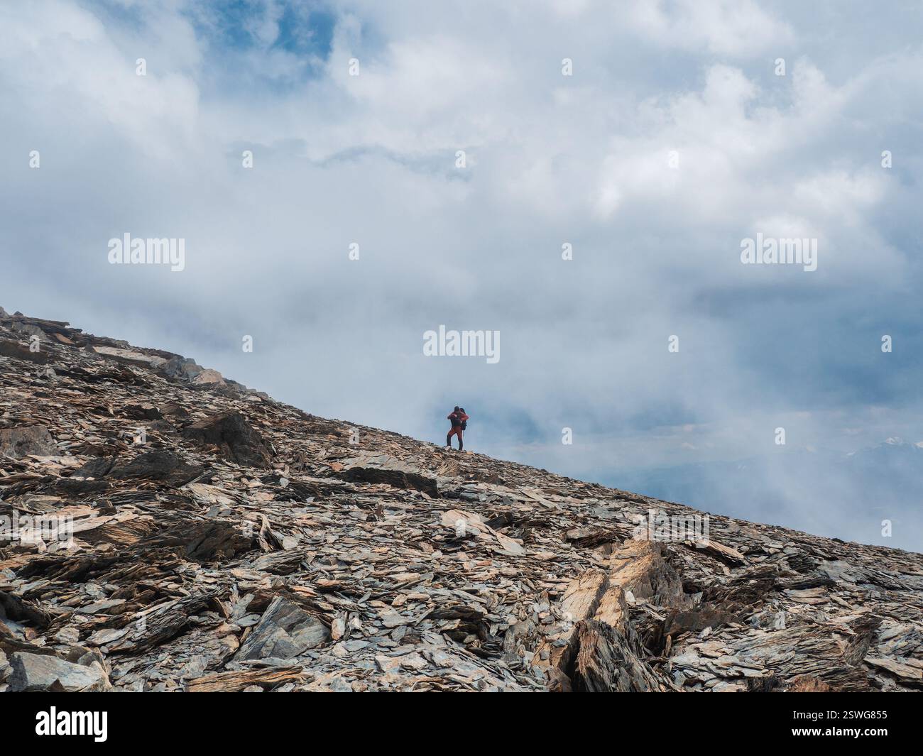 Heavy climbing on sharp rocks. Solo trekking in the mountains. Travel ...