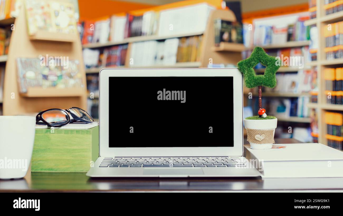 Workspace setup at a cozy bookstore with a laptop and decorative items ...