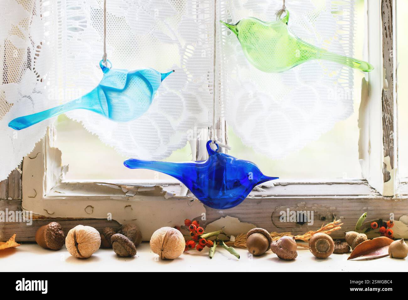 Interior window with glass birds and nuts Stock Photo - Alamy
