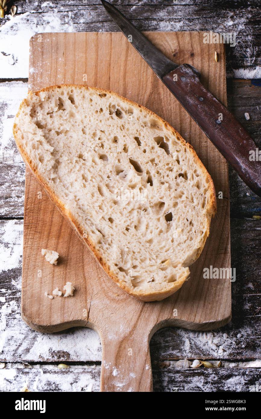 Sliced homemade bread on wooden cutting board with vintage knife ...