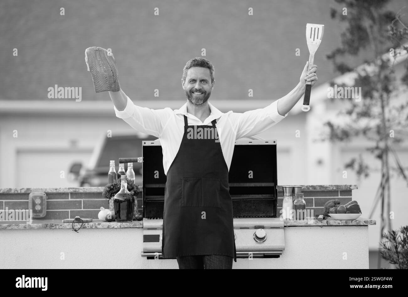 Grill cook. Chef in cook apron with BBQ cooking tools. Barbecue and ...