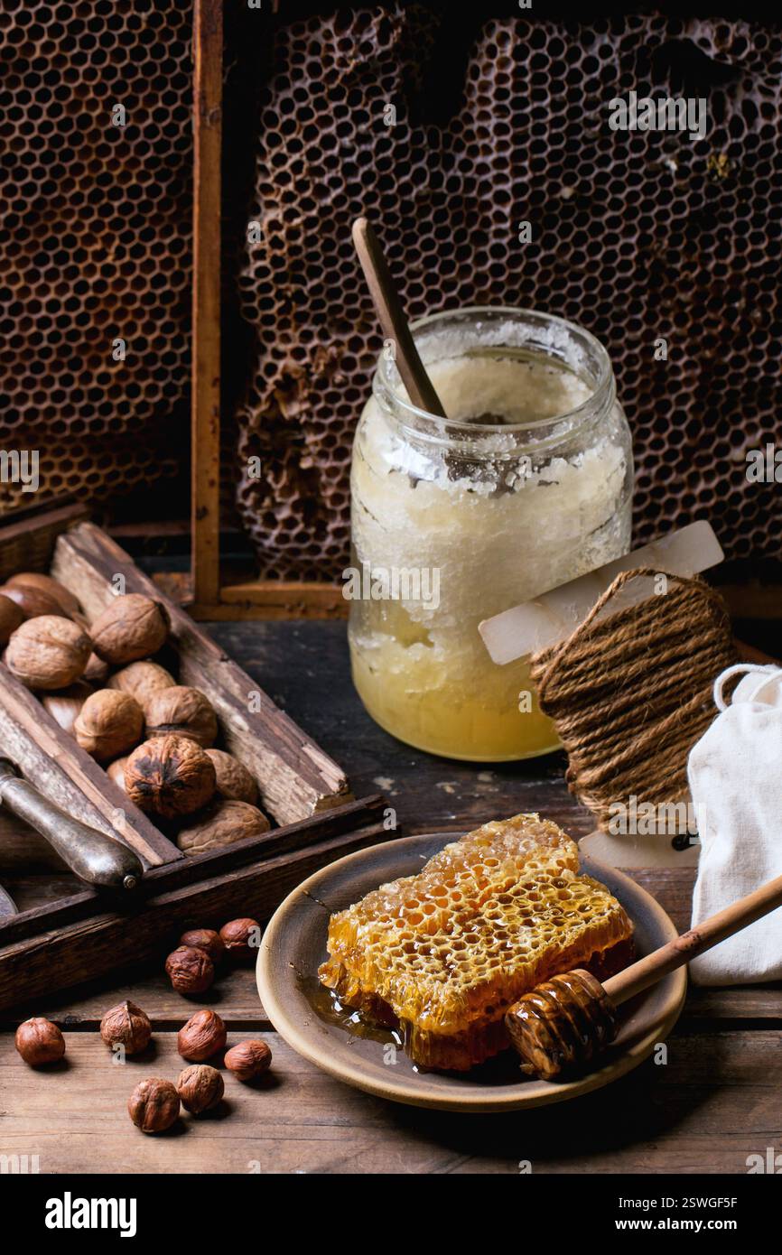 Fresh honeycomb with jar of old honey and mix of nuts over old wooden ...