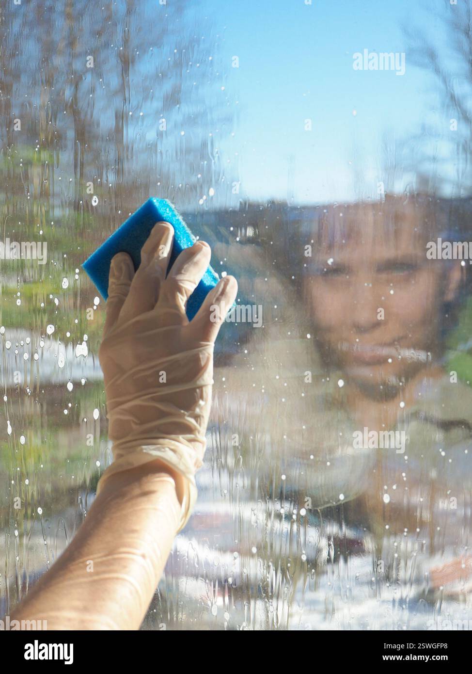 Woman washes the window with a sponge. House cleaning. Washing dirty ...