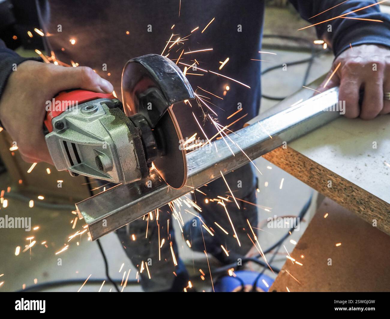 Circular saw sawing with sparks. A man working with electric grinder ...