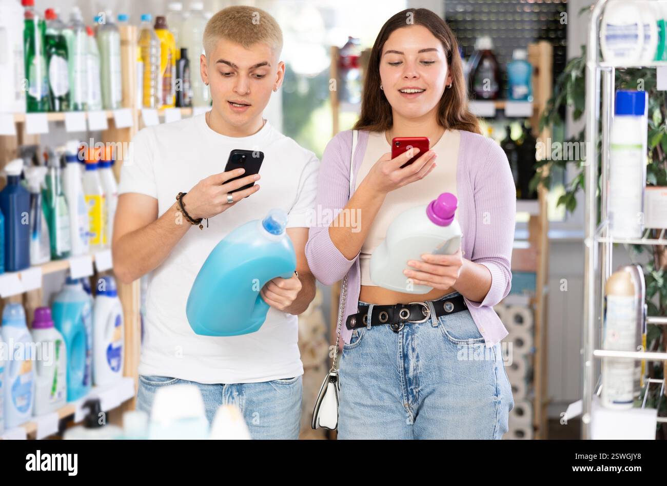 Young couple scanning QR-code on detergent in department store Stock ...