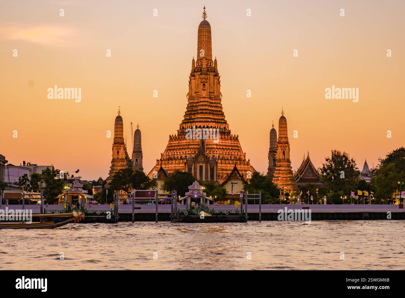 Golden light bathes Wat Arun, the Temple of Dawn, as dusk descends over ...