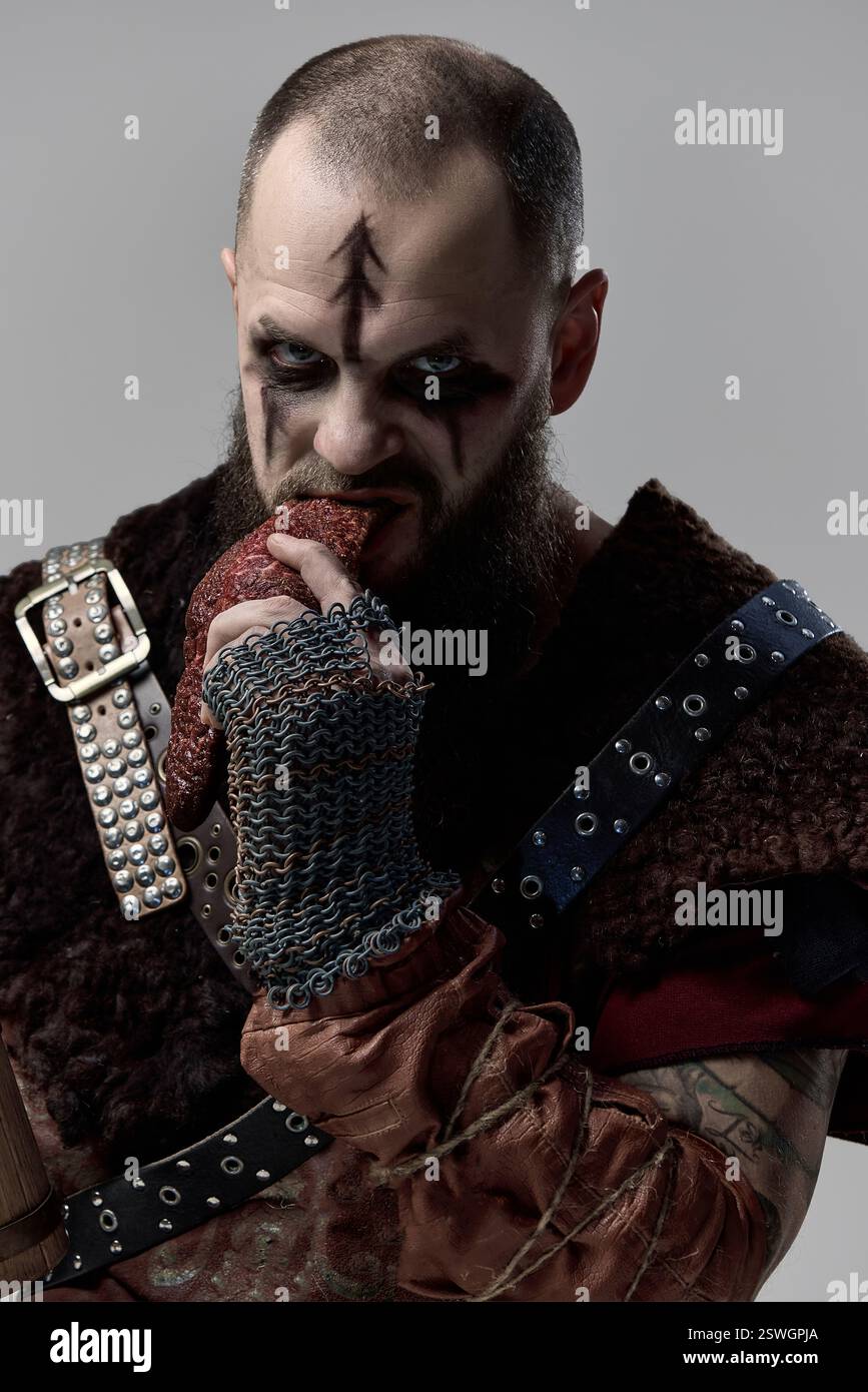 Close-up of Viking warrior in full armor, with intense gaze biting raw ...