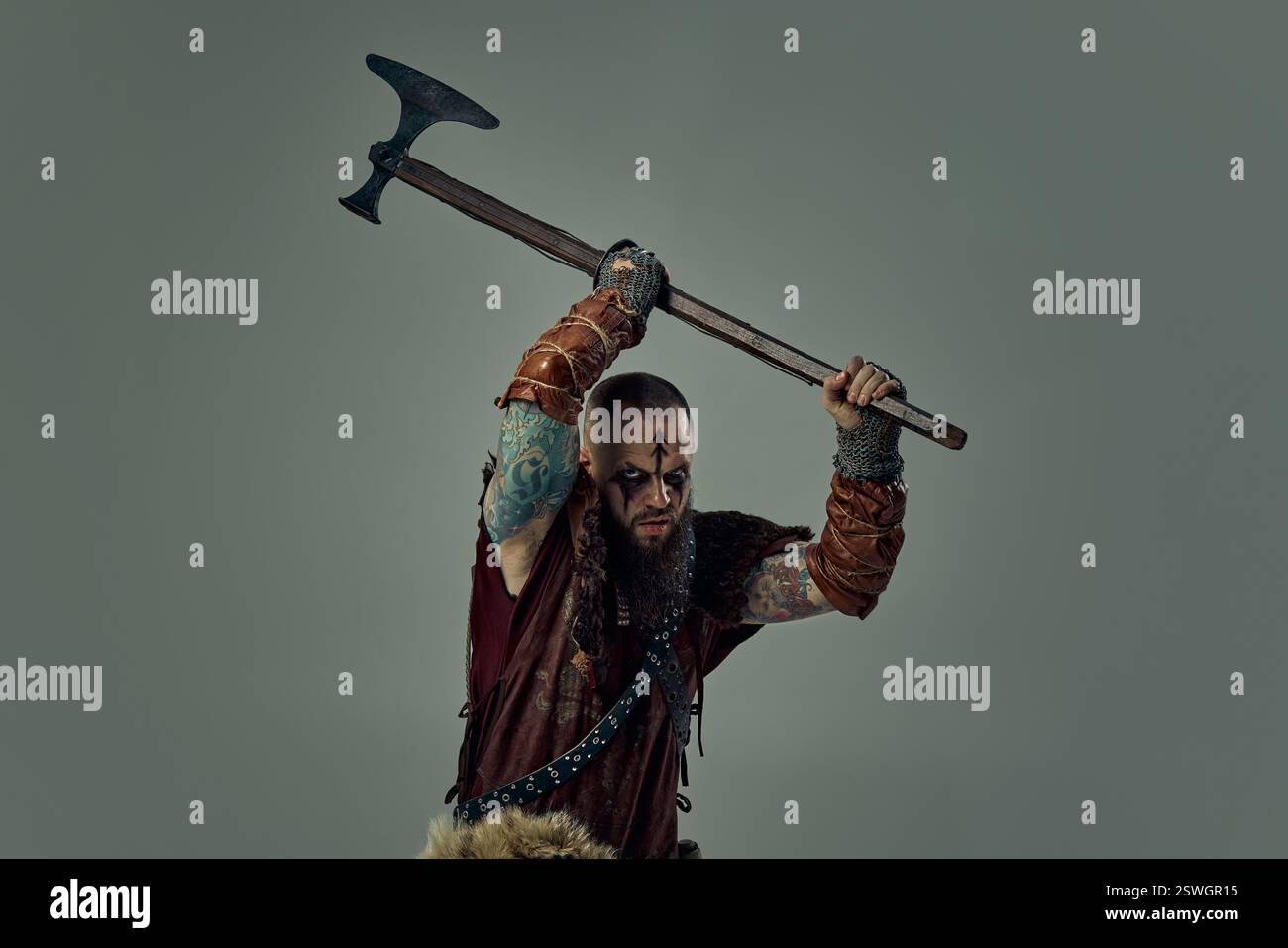 Fierce man, medieval Viking warrior in leather armor raising massive ...