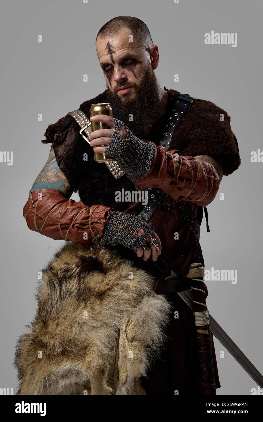 Portrait of Viking warrior gripping golden beer bottle, wearing fur ...