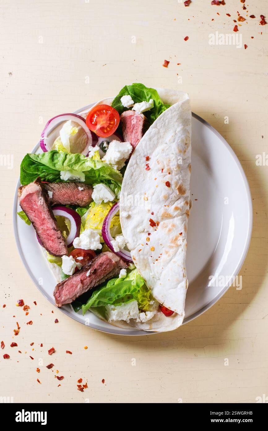 Overhead view on plate with taco with feta cheese and beef over white ...