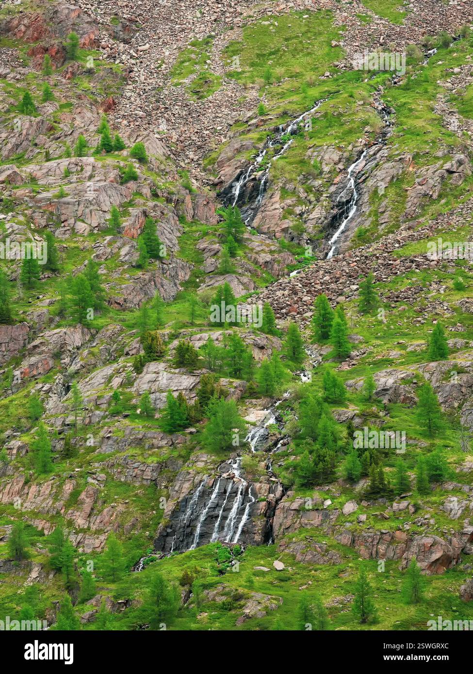 Waterfall sleeves. Scenic distance alpine landscape with trees in slope ...