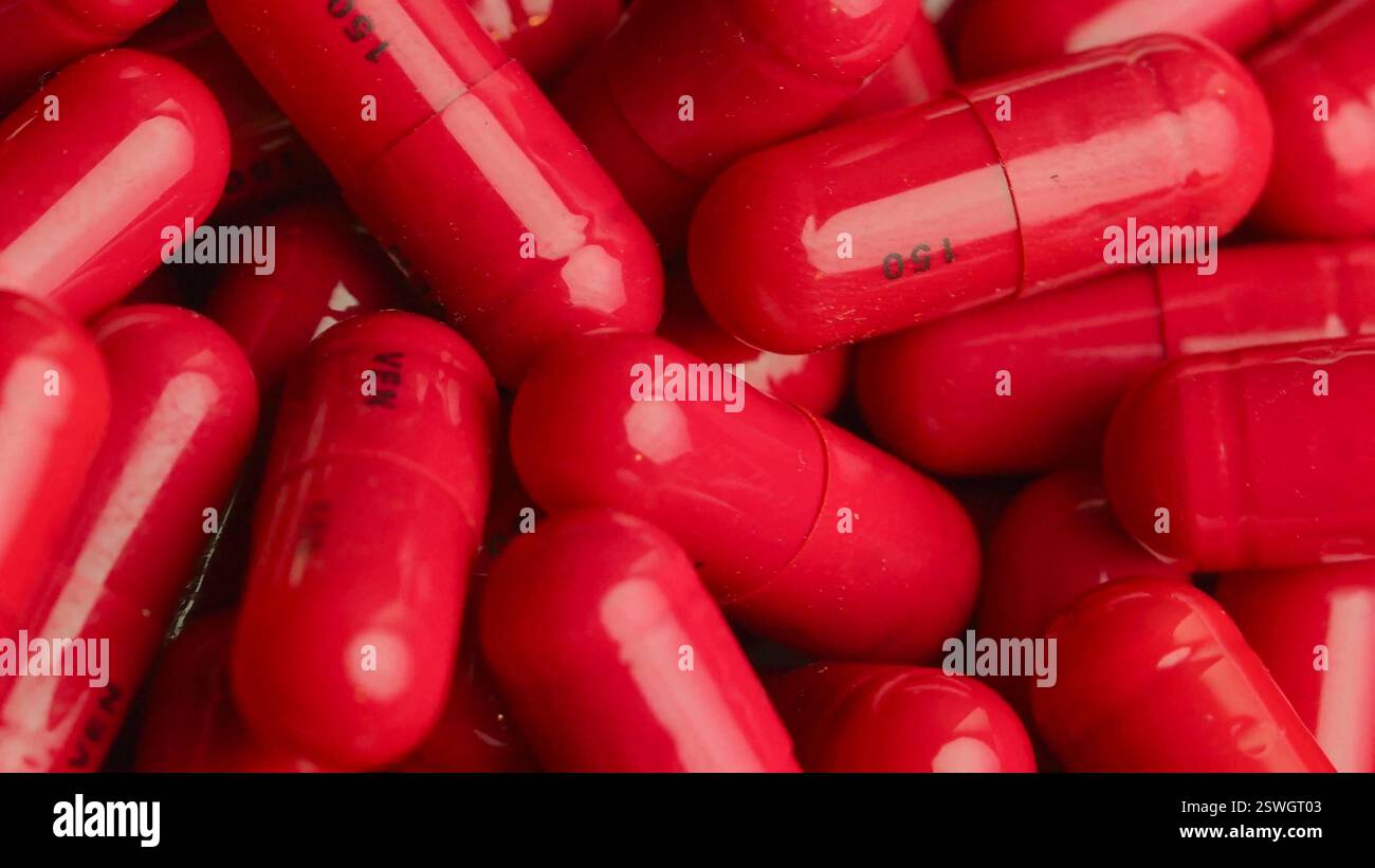 A stack of drugs, pills. Red medical tablets. Medication on a rotating ...