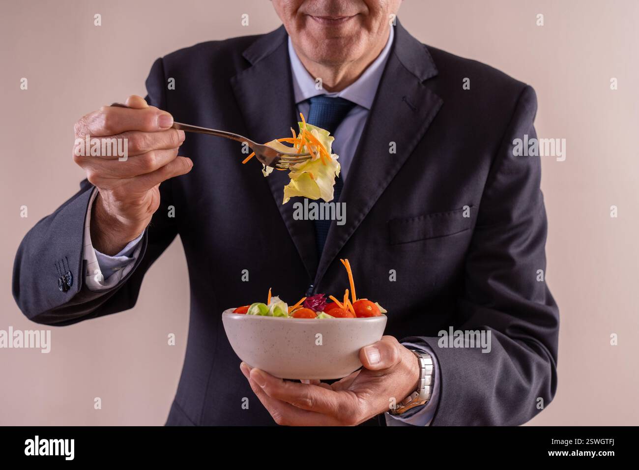 Professional senior man eating a fresh salad, promoting healthy eating ...