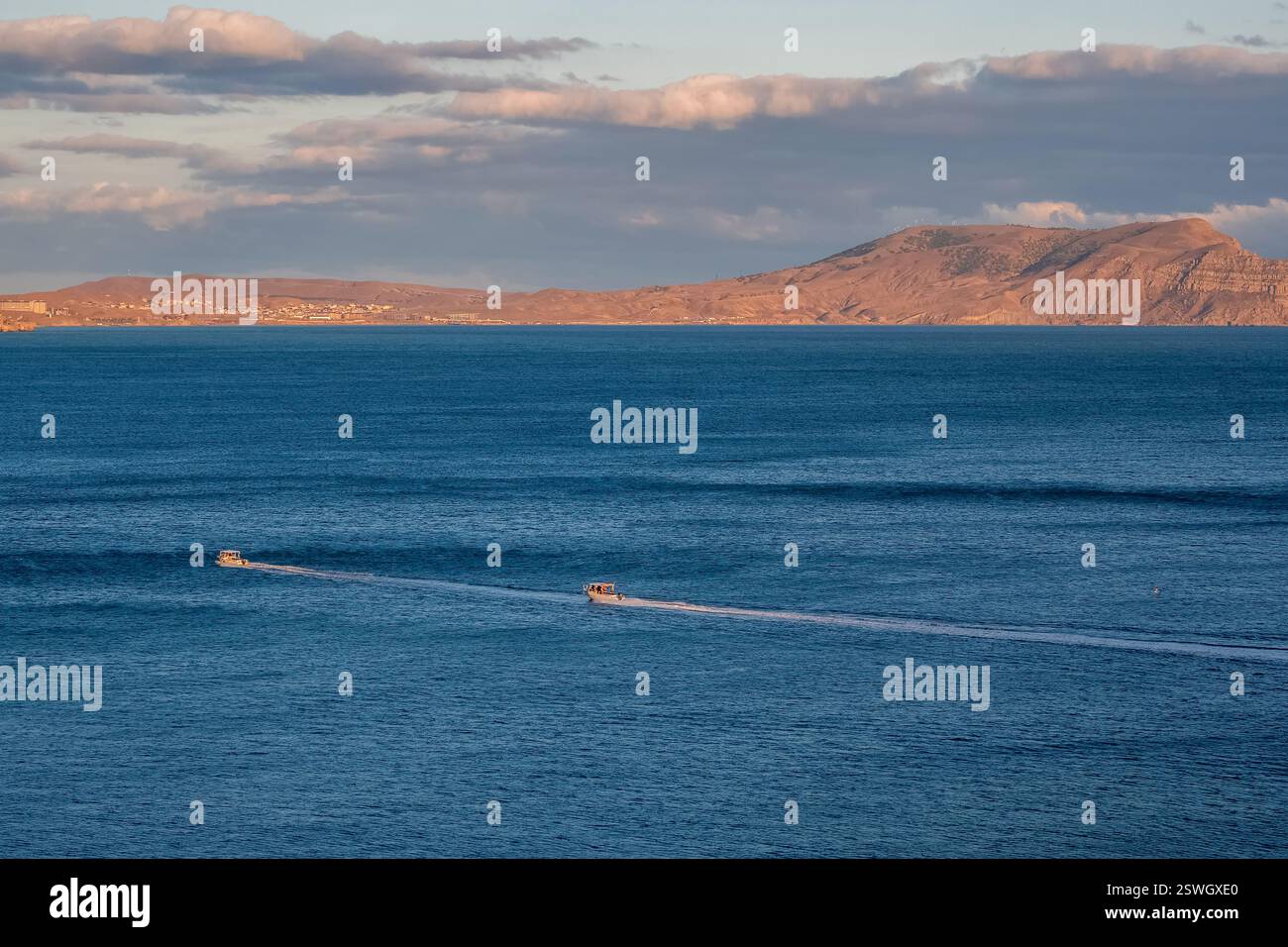 Black sea coast. Little boats in the sea near rock cliff. White boats ...
