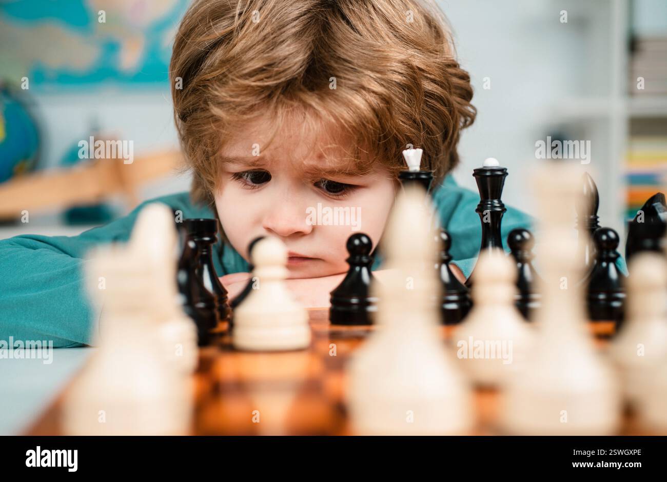 Son are playing chess and smiling at home. Kids early development. Boy ...