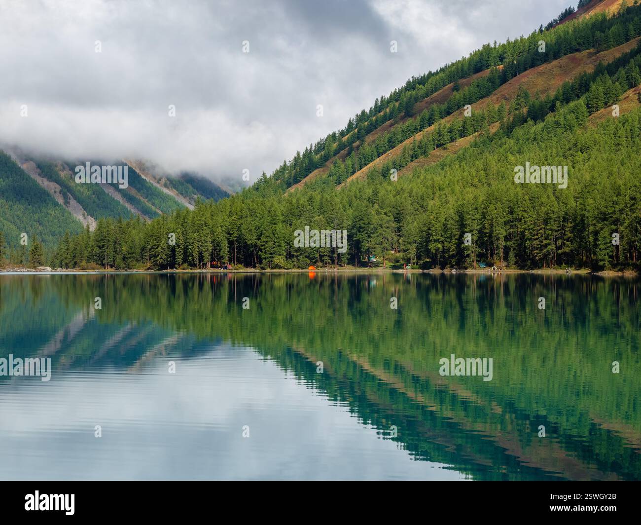 Camping on the shore of a clean mountain lake. Mystical morning ...