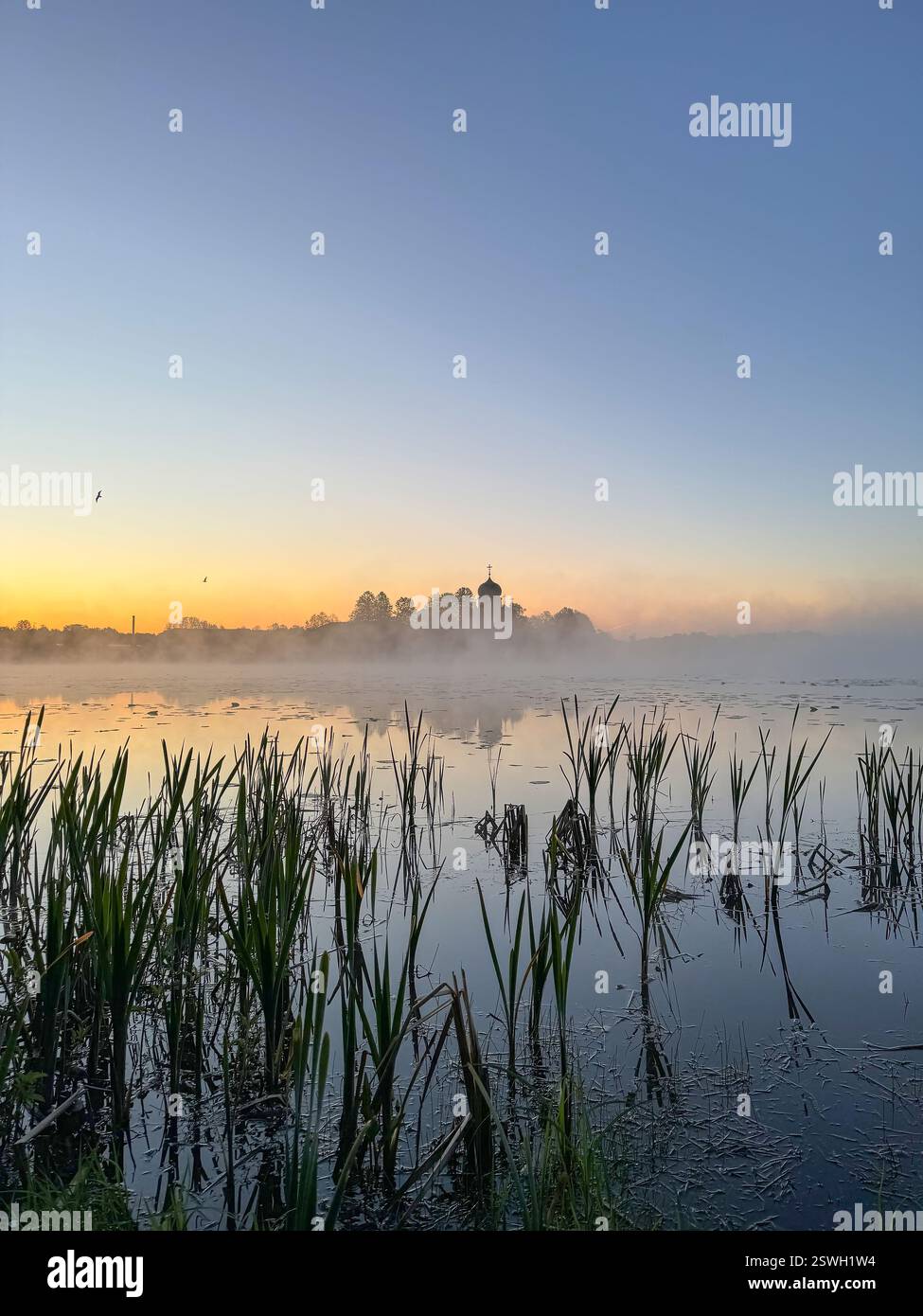 Morning landscape, sunrise on the river. Vertical view of the monastery ...