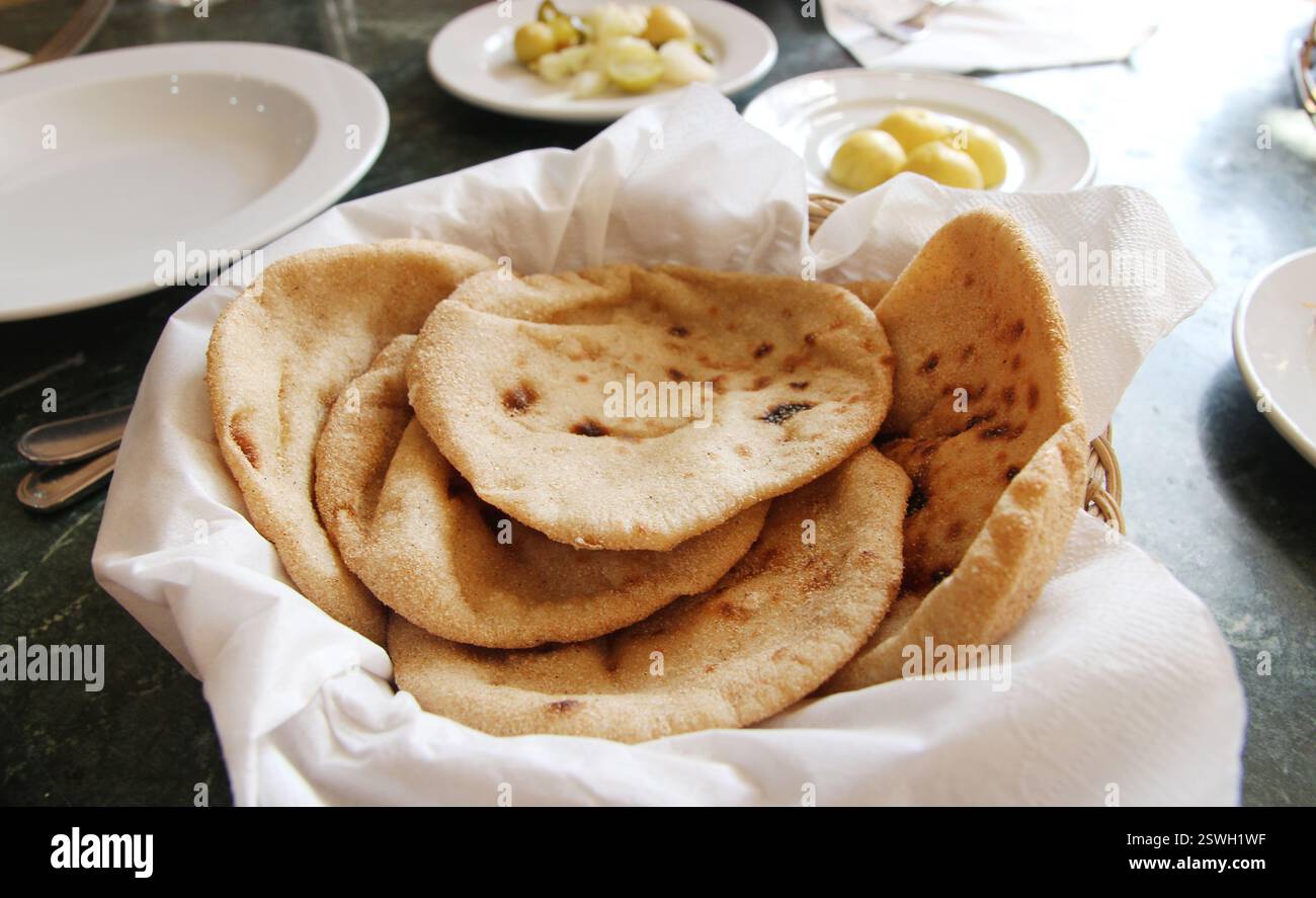 Egyptian flatbread Aish Baladi with side dishes in a Luxor restaurant ...