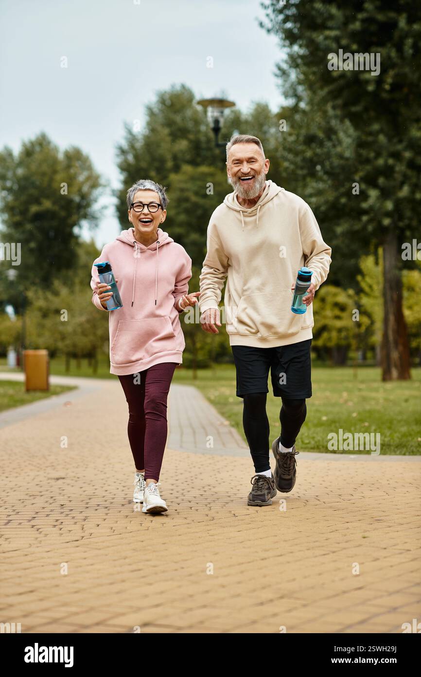 Two happy seniors jog together in a scenic park, sharing a moment filled with joy and connection ...