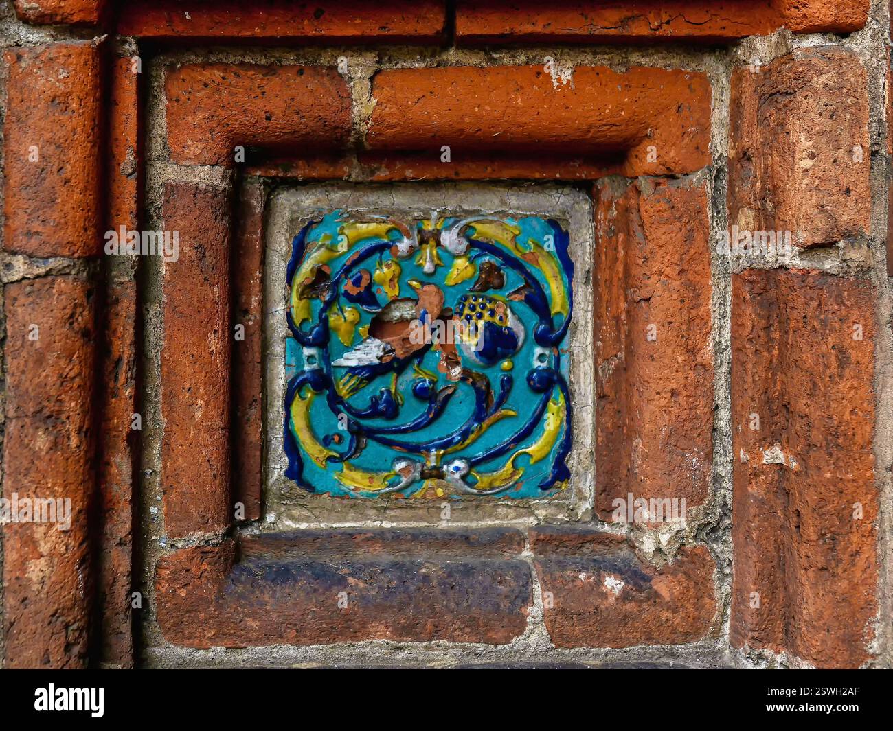 Ancient tiles in the red brick wall close up. Tile on exterior decor ...