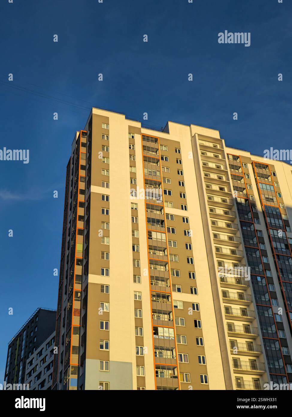 Sunny evening light on the facade of a multi-storey building. Facade ...