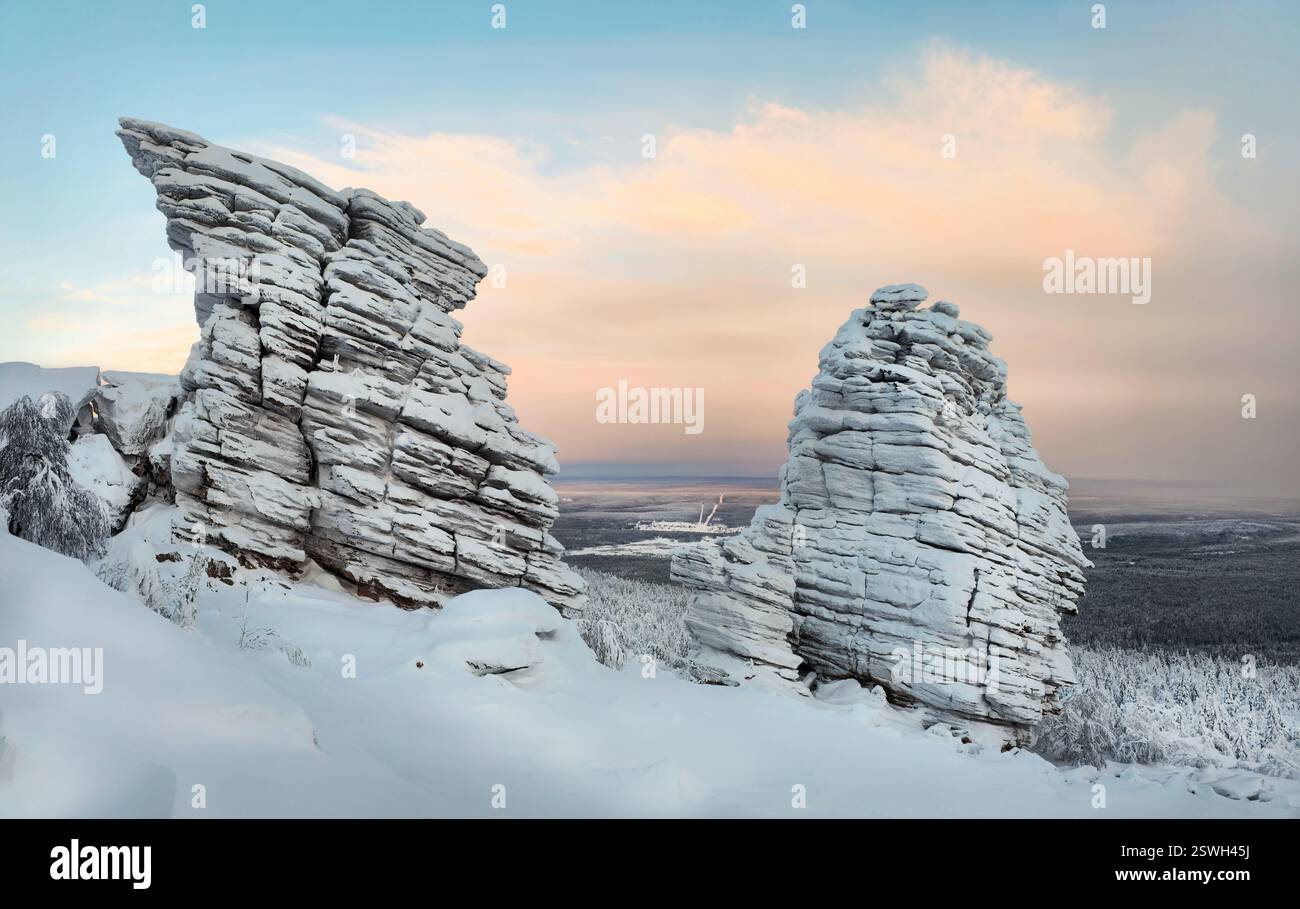 Mystical dawn in the snow-covered mountains. Rock pillars, weathering ...