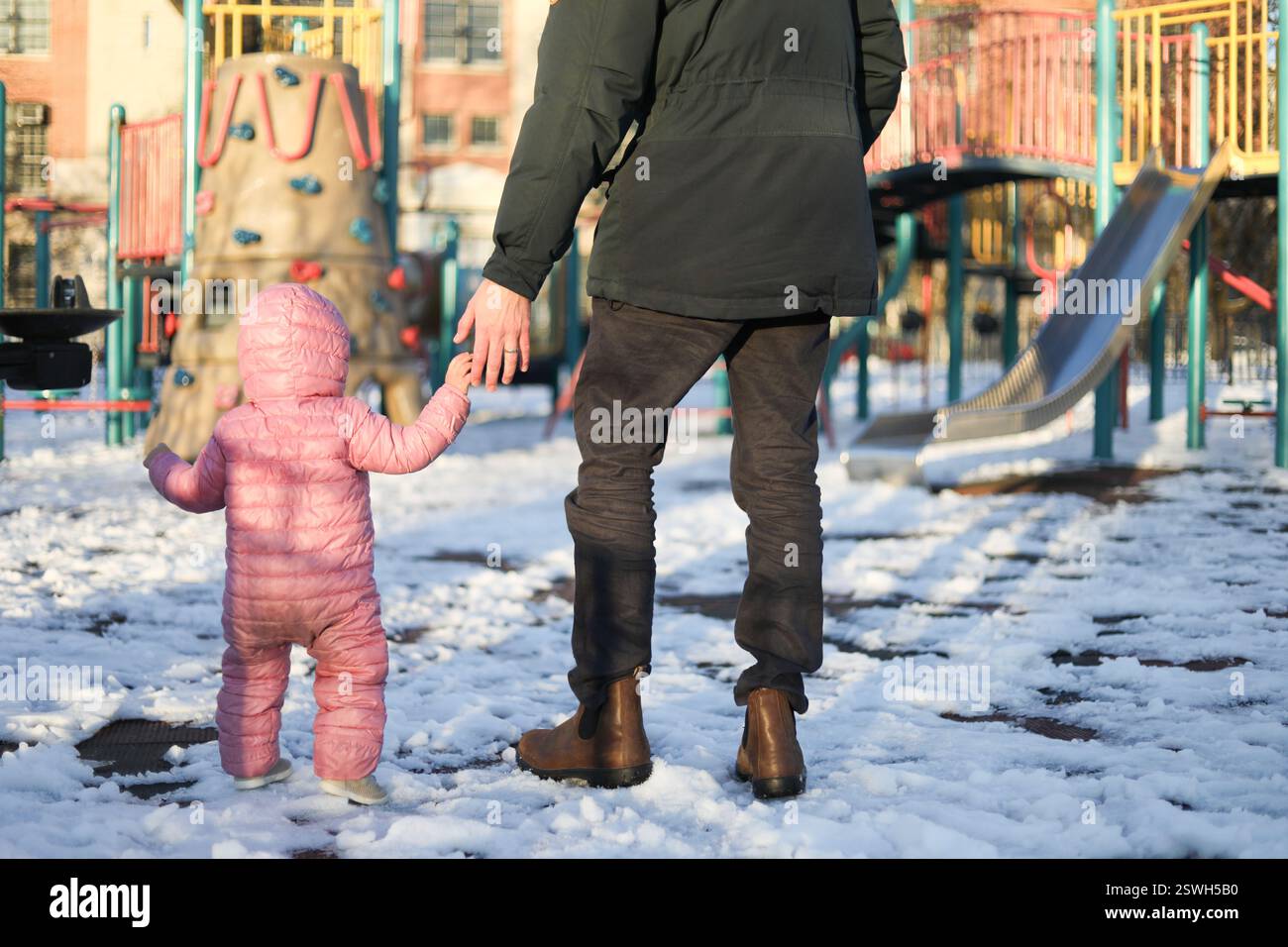 Dad Reaching for Daughters Hand on Snowy Playground Stock Photo - Alamy