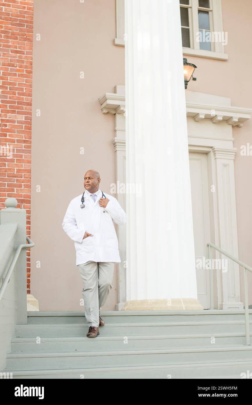 Confident doctor walking down steps outside a historic building Stock ...