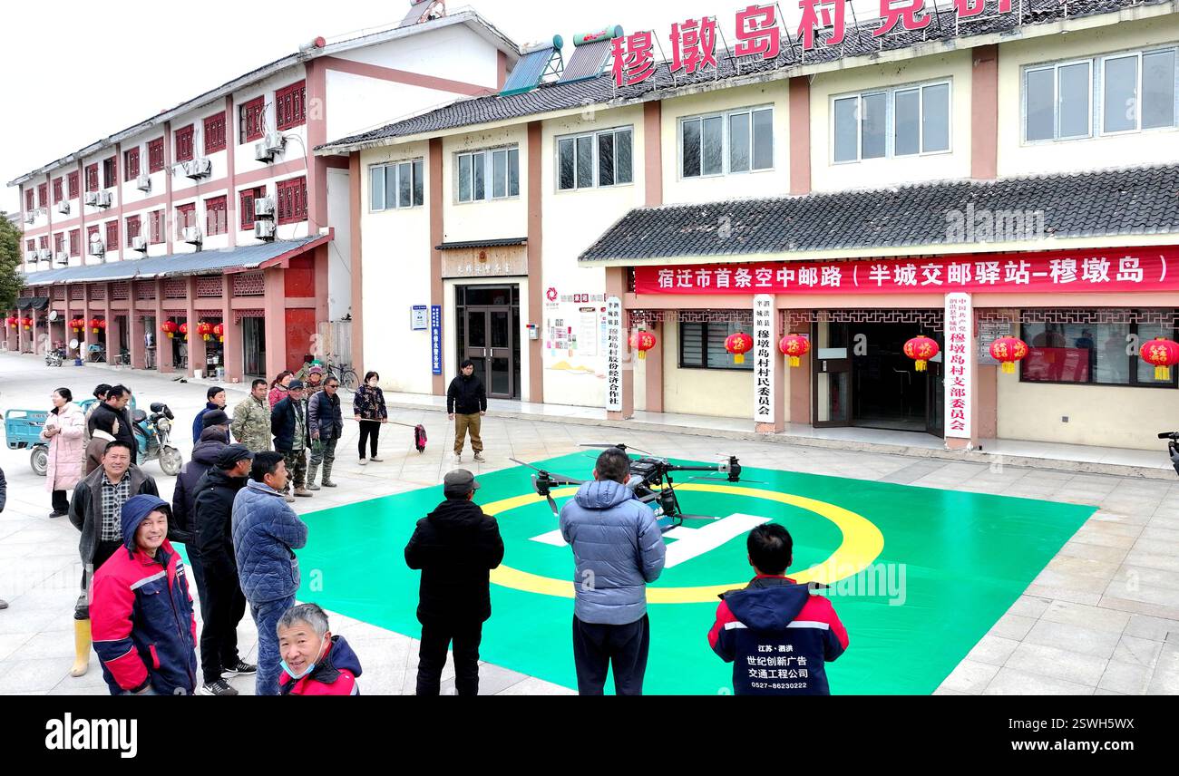 SUQIAN, CHINA - FEBRUARY 21, 2025 - A Courier puts a delivery into a ...