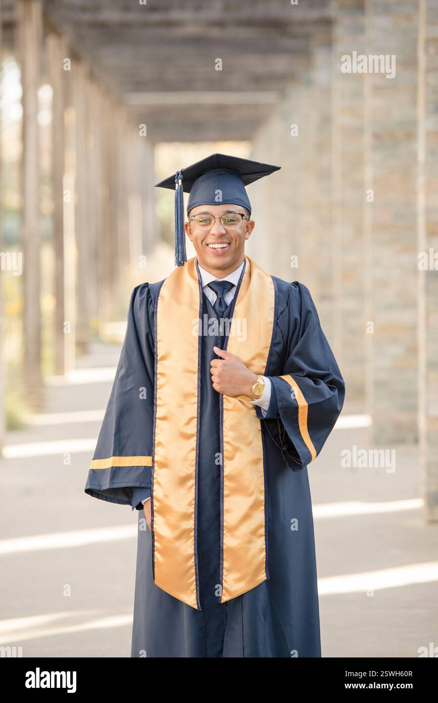 Proud graduate in cap and gown celebrating achievement Stock Photo - Alamy
