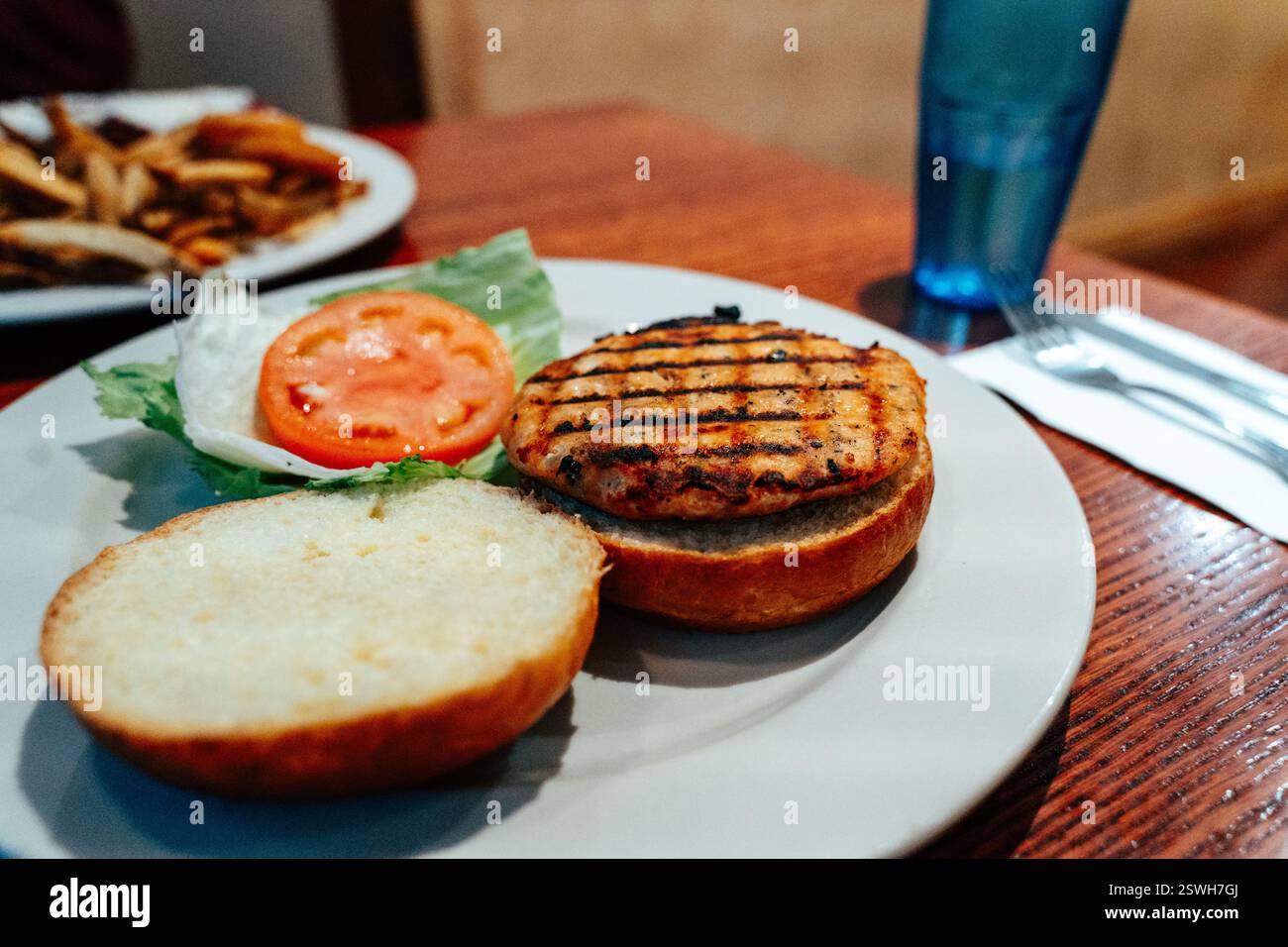 Delicious fish burger served at a cozy diner with fresh toppings Stock ...