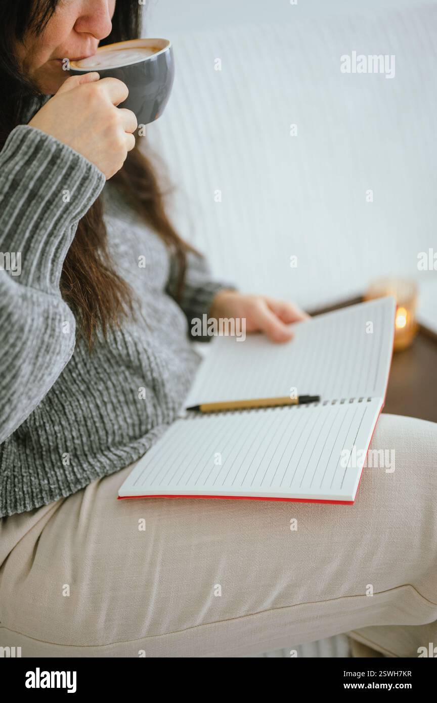 Woman sipping coffee while journaling during morning routine Stock ...
