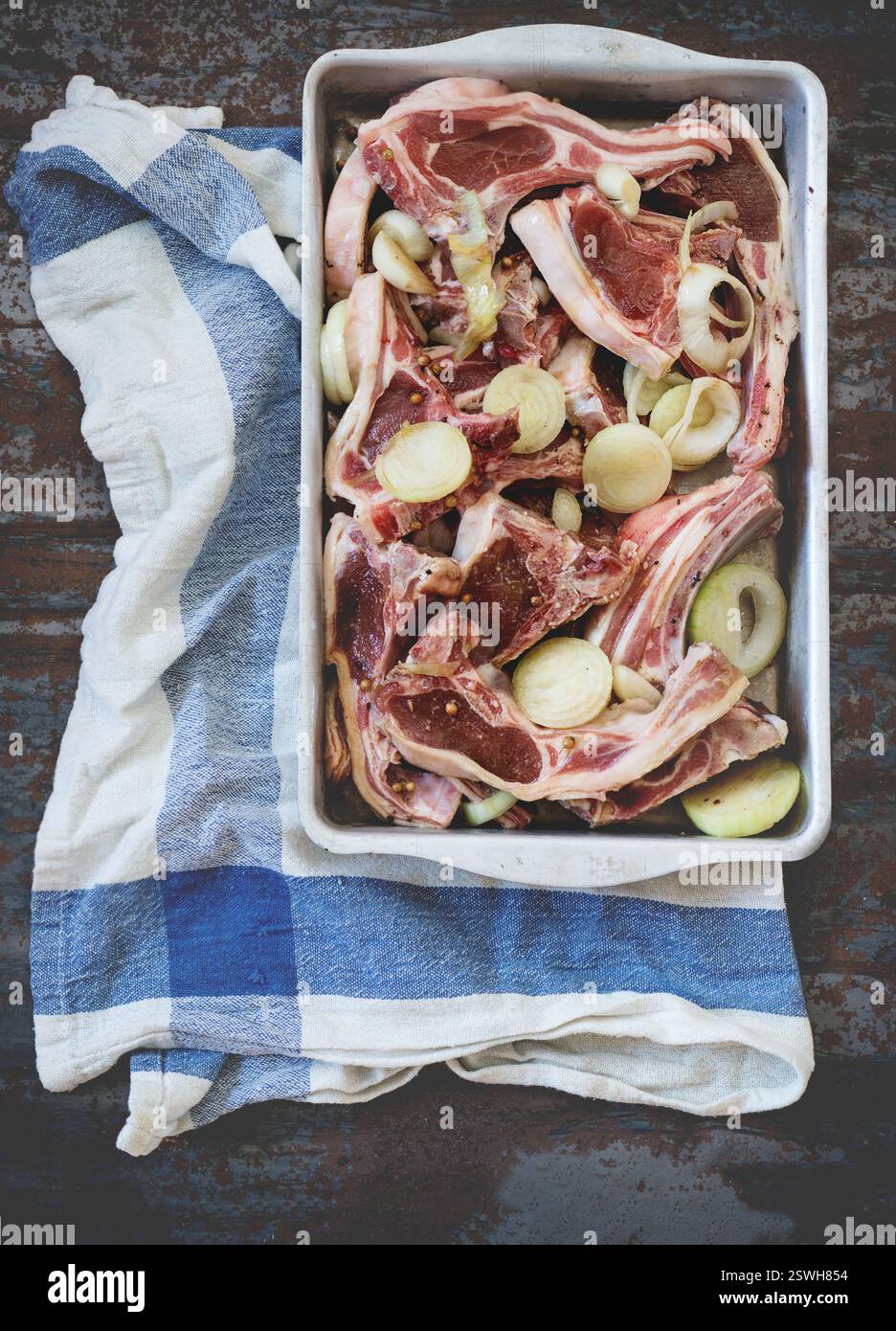 Marinating of raw lamb chops with onion and peppers in old aluminum ...