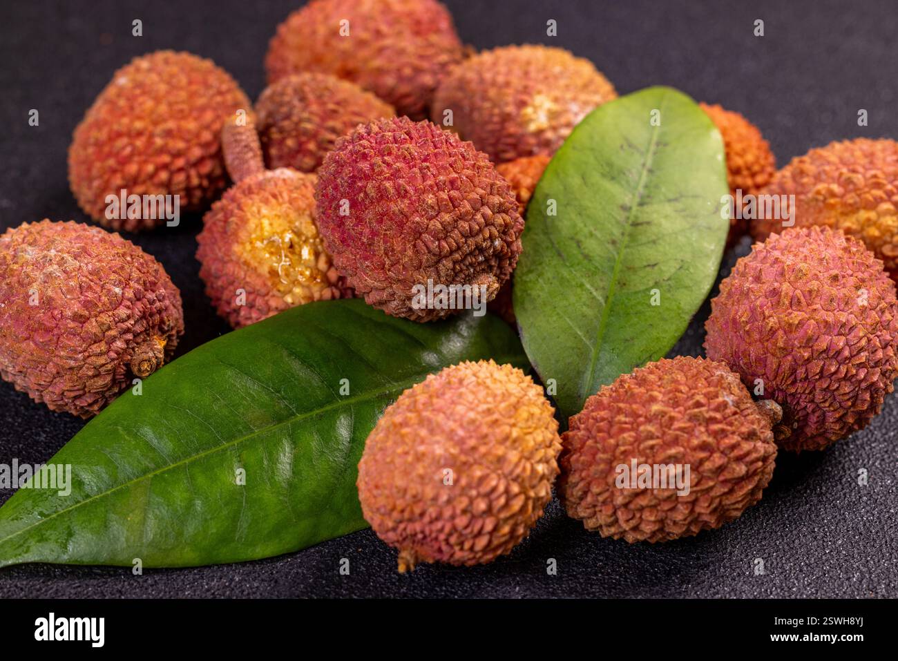 Ripe lychees and lush green leaves create a visually appealing display ...