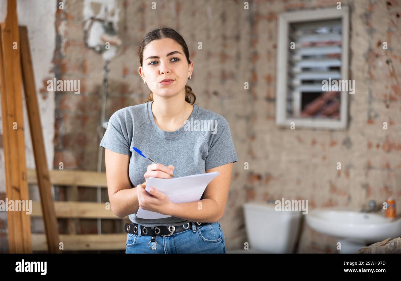 Young woman making notes with planning upcoming home overhaul Stock ...
