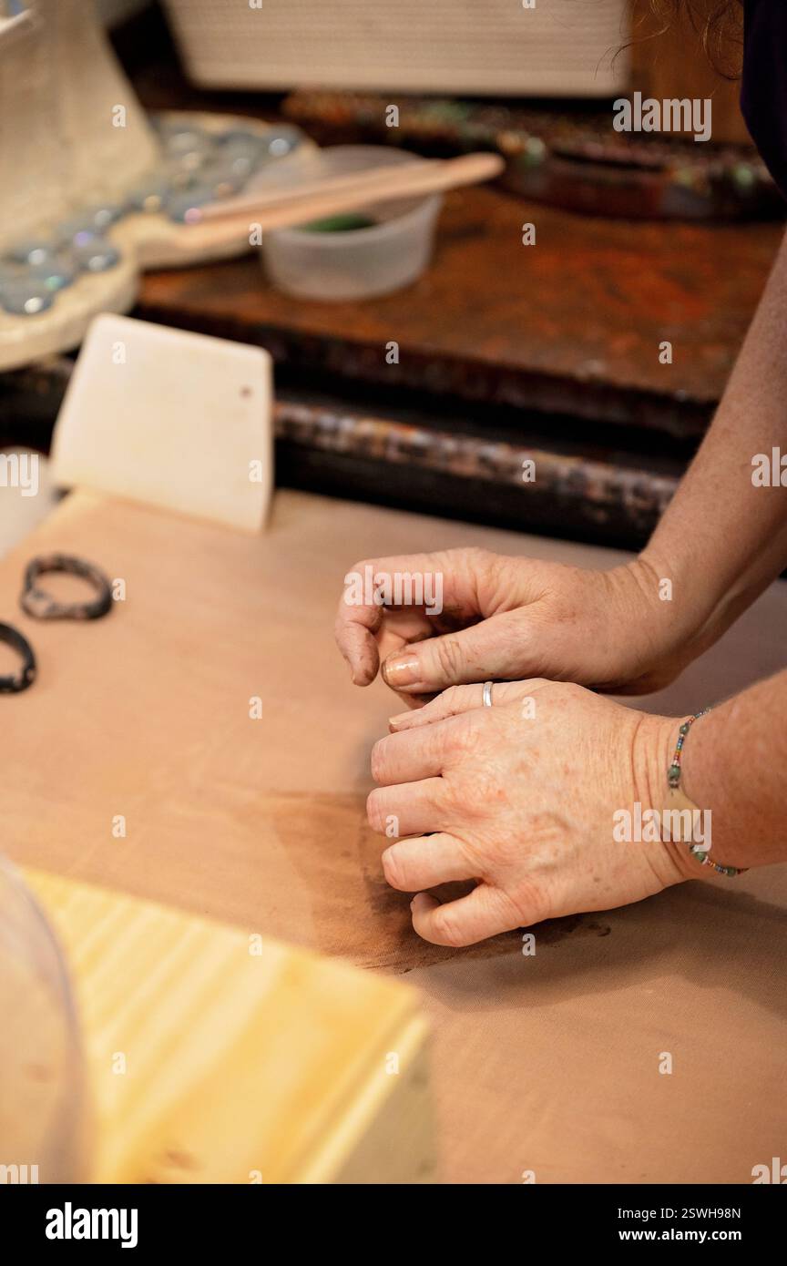 Artisan's hands shaping clay in a pottery studio workspace Stock Photo ...