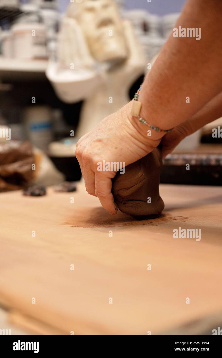Artisan's hands kneading clay in a pottery studio workspace Stock Photo ...