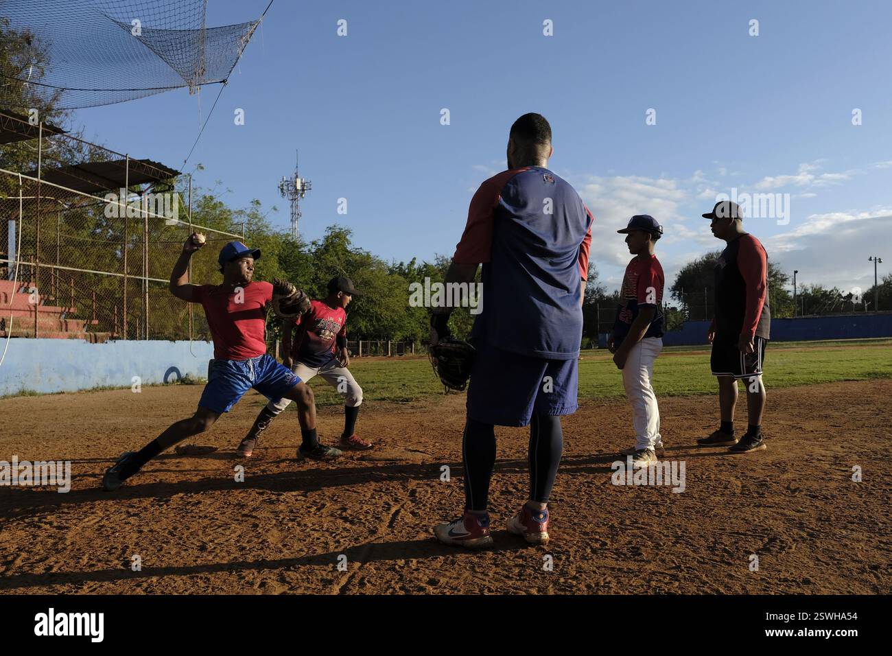 Teenage baseball players practice during their daily training at the Trinitarios ballpark in ...