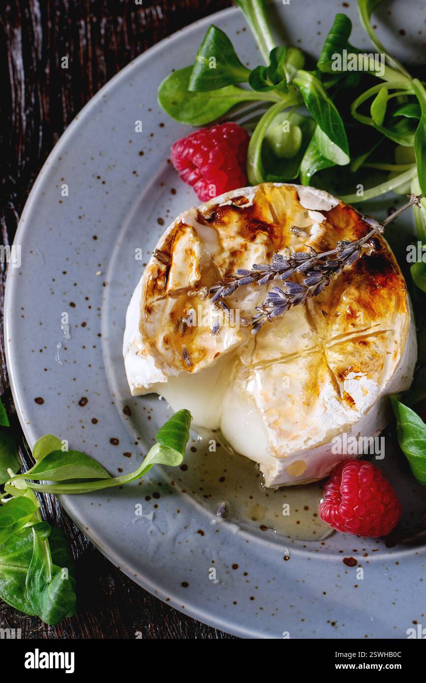 Baked Goat cheese with honey and raspberries Stock Photo - Alamy