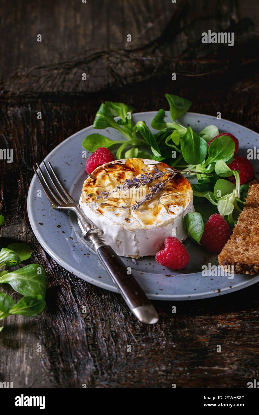 Baked Goat cheese with honey and raspberries Stock Photo - Alamy