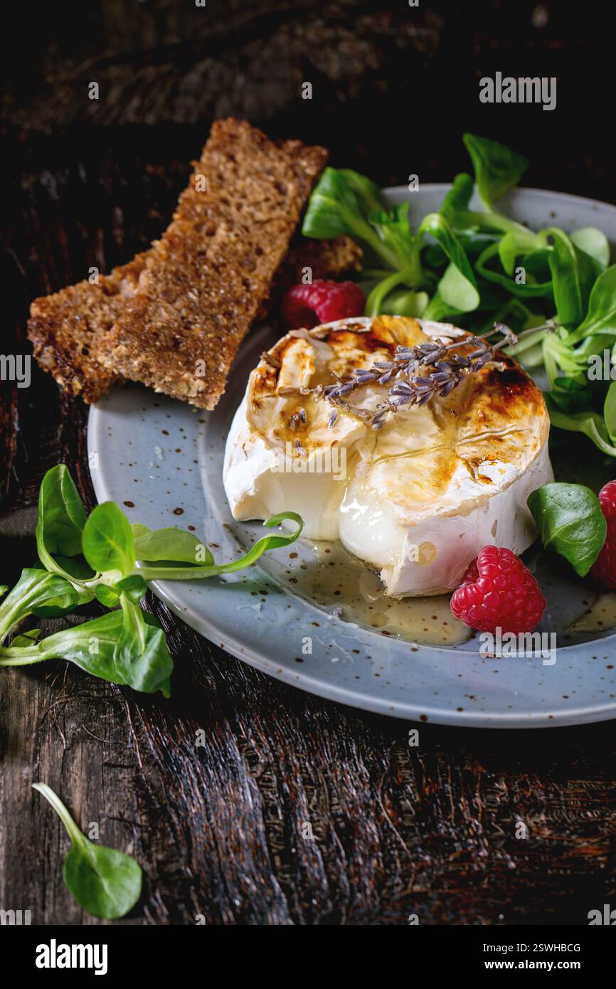Baked Goat cheese with honey and raspberries Stock Photo - Alamy