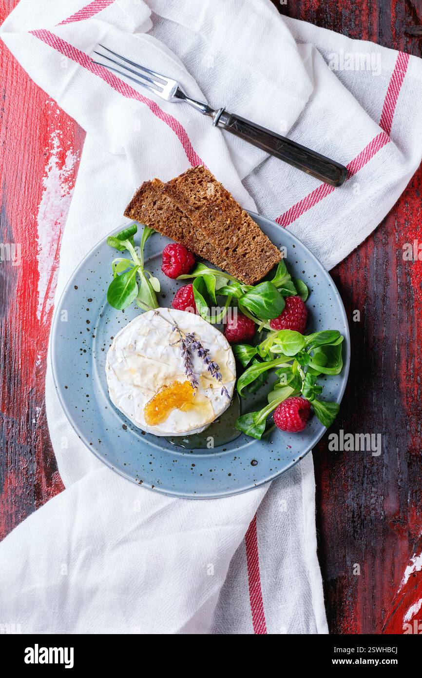 Goat cheese with honey and raspberries Stock Photo - Alamy