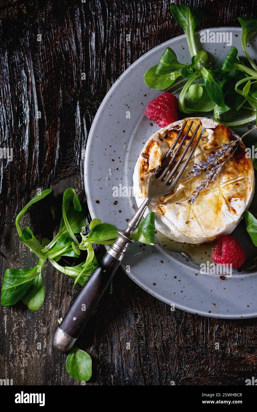 Baked Goat cheese with honey and raspberries Stock Photo - Alamy