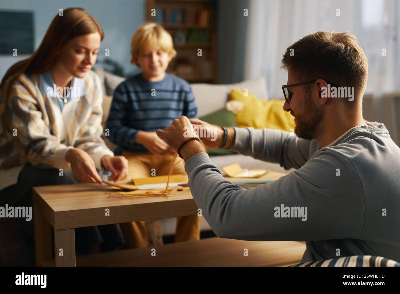 Family members bonding around table with focus on board games, engaging ...