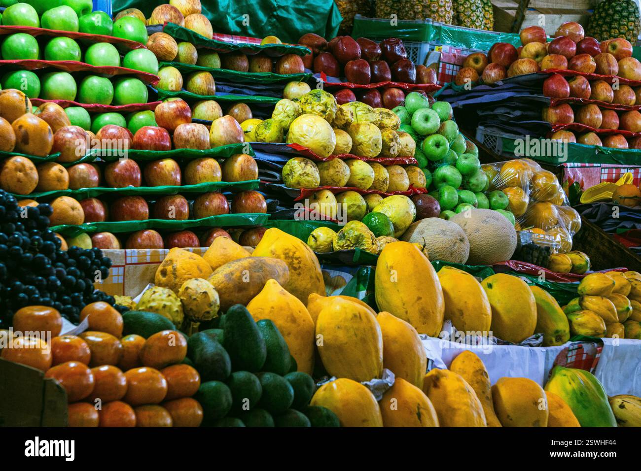 A colorful Peruvian fruit stand featuring fresh mangoes oranges grapes ...