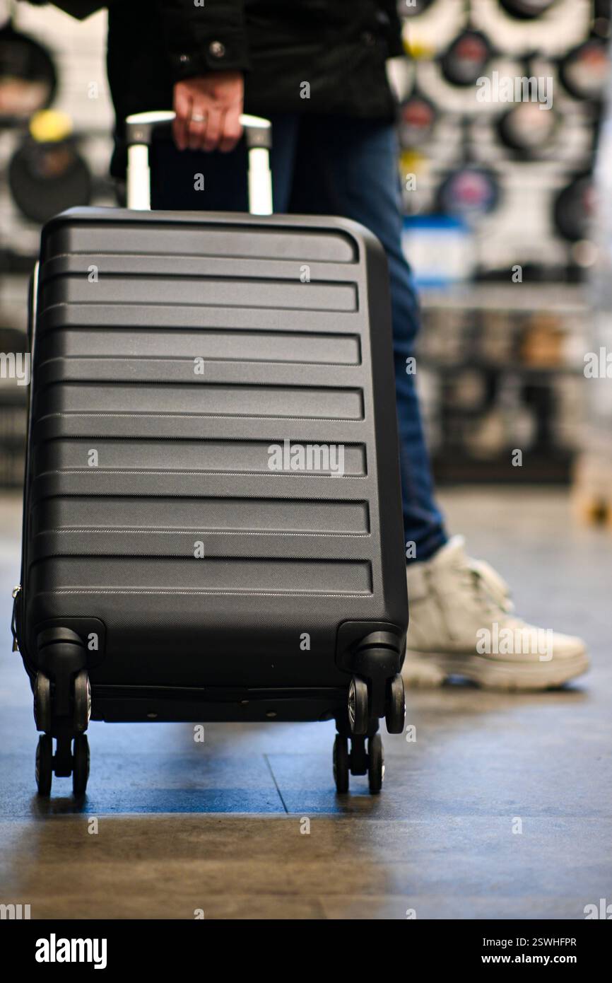 Tourist walking with rolling suitcase in airport terminal, ready for ...
